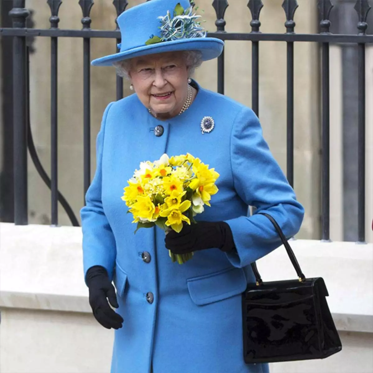 Queen holder en buket af gule blomster