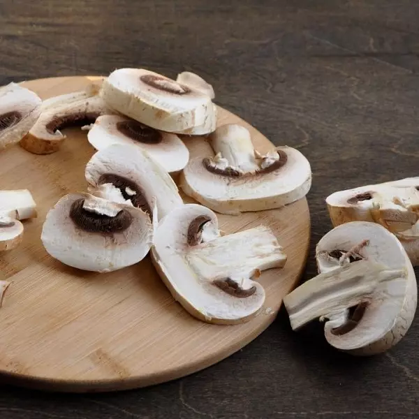 Placas de champiñones en una tabla de cortar.